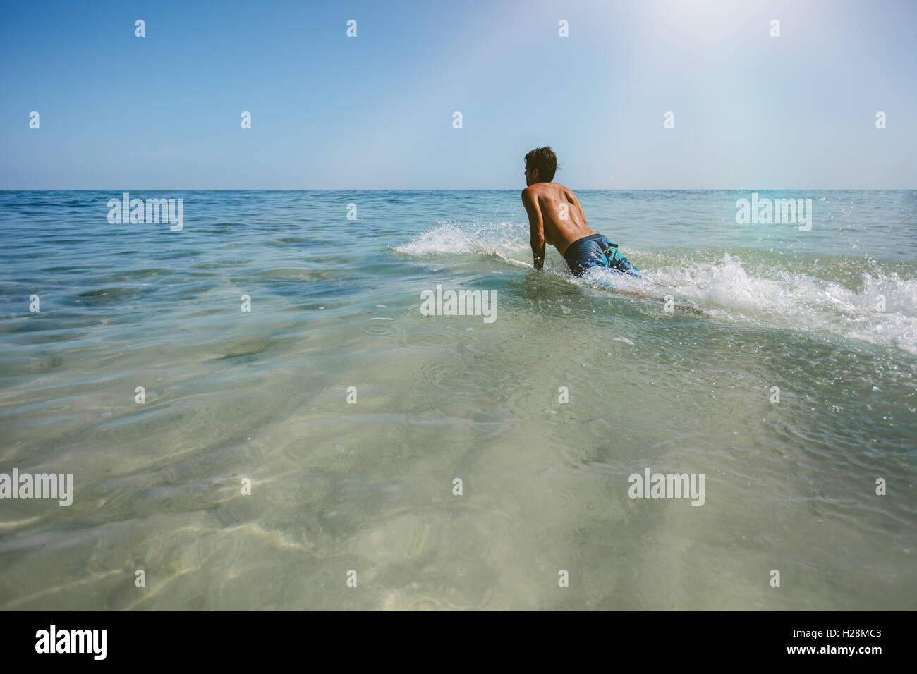 Shot of young man enjoying a surf in sea water. Male surfer in the ...