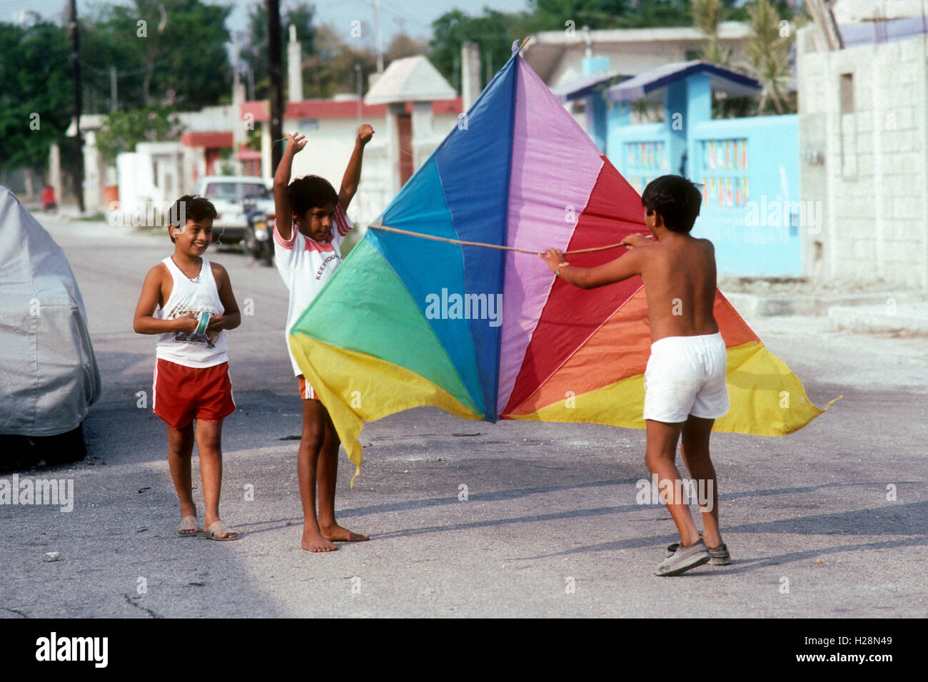 Children playing with a kite in a street in Cozumel, Mexico Stock Photo ...
