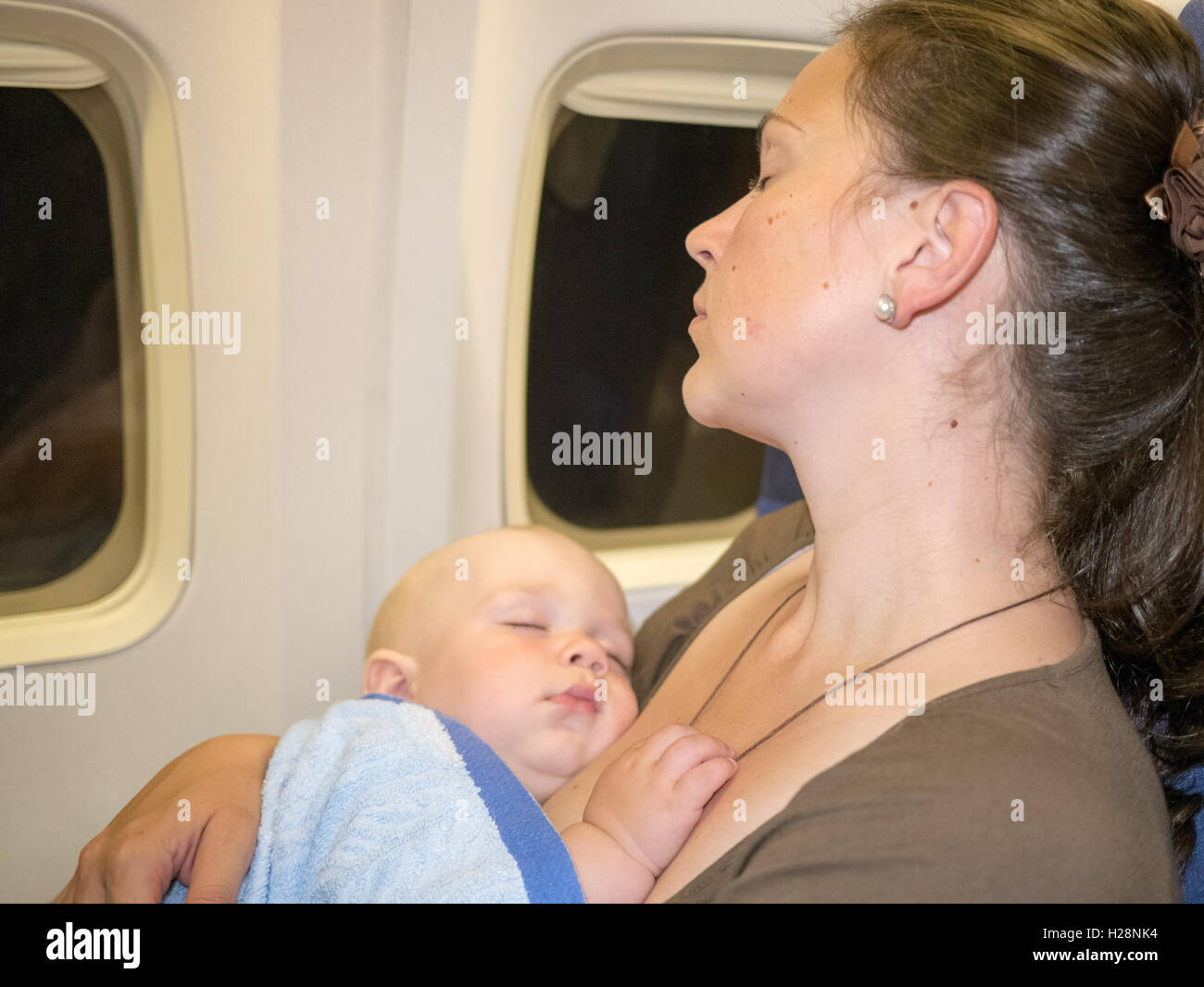 Mother hug and sleep with her newborn baby during flight. Concept photo ...