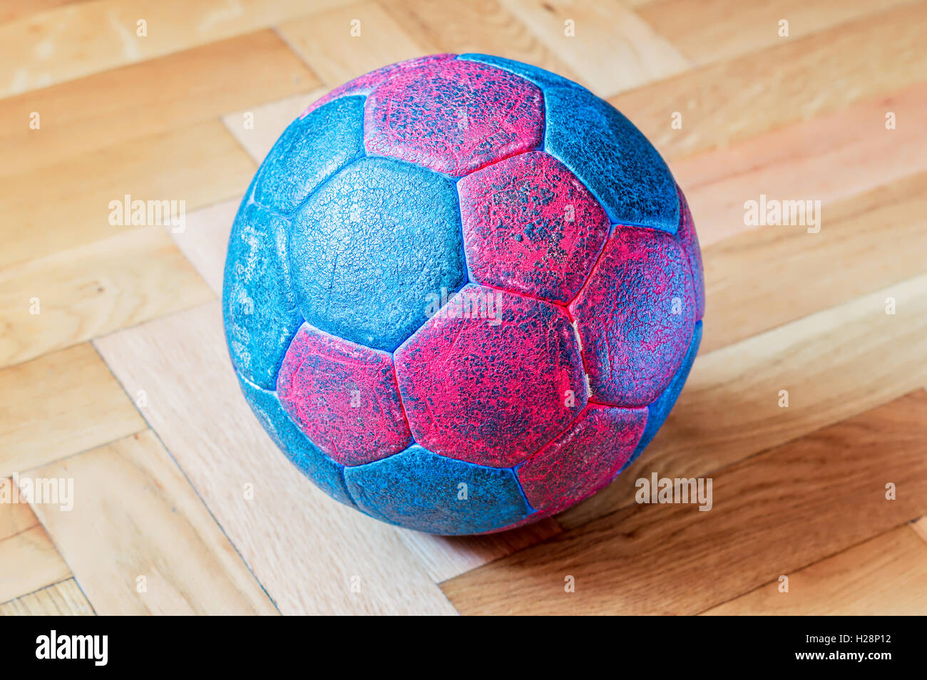 Dirty blue and red handball ball on a wooden parquet floor Stock Photo ...