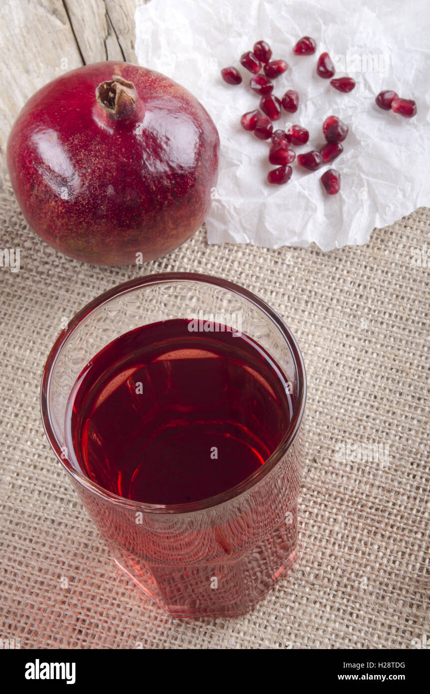pomegranate juice in a glass on jute Stock Photo - Alamy