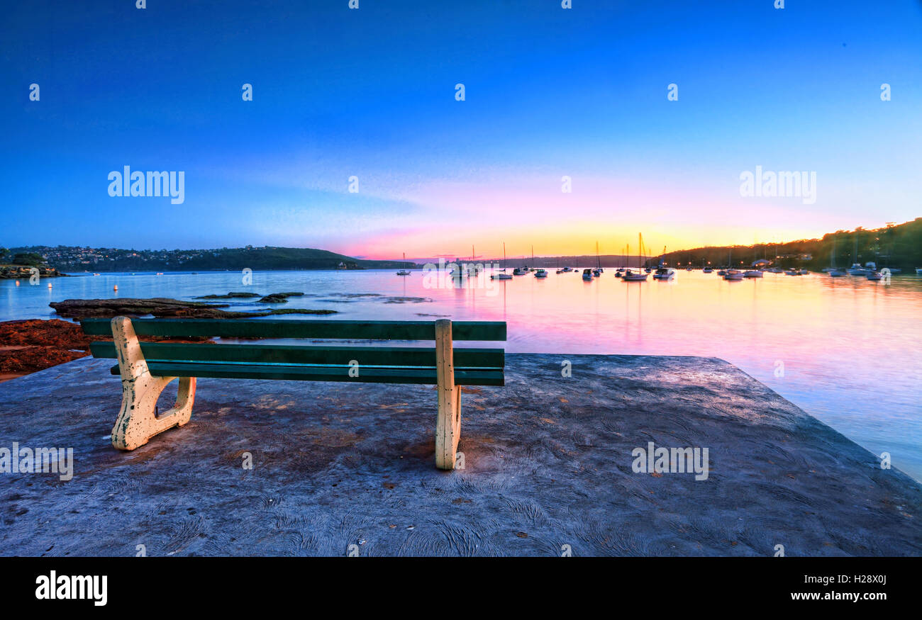 Park bench with a seascape view sunrise Stock Photo - Alamy