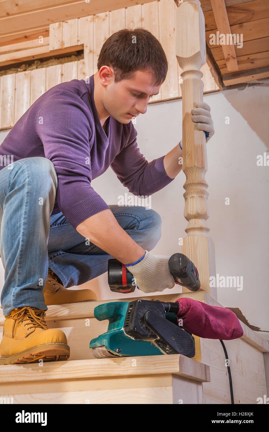 a young carpenter fixing post of ladder Stock Photo - Alamy
