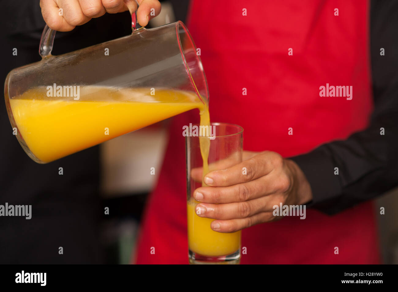 Guy pouring fresh juice in glass Stock Photo - Alamy