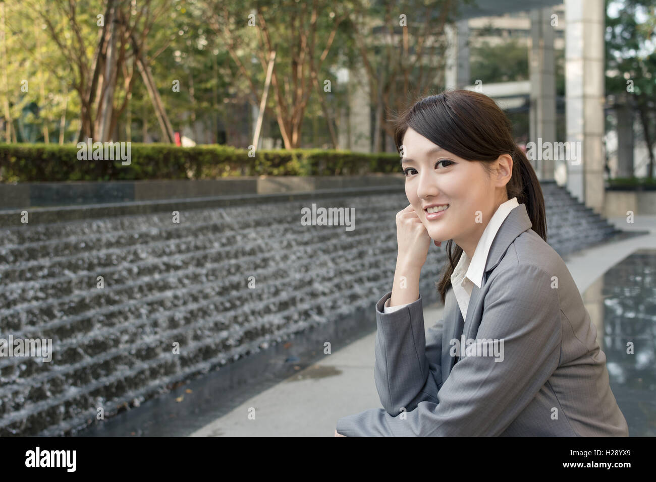 Asian business woman thinking in the city Stock Photo - Alamy