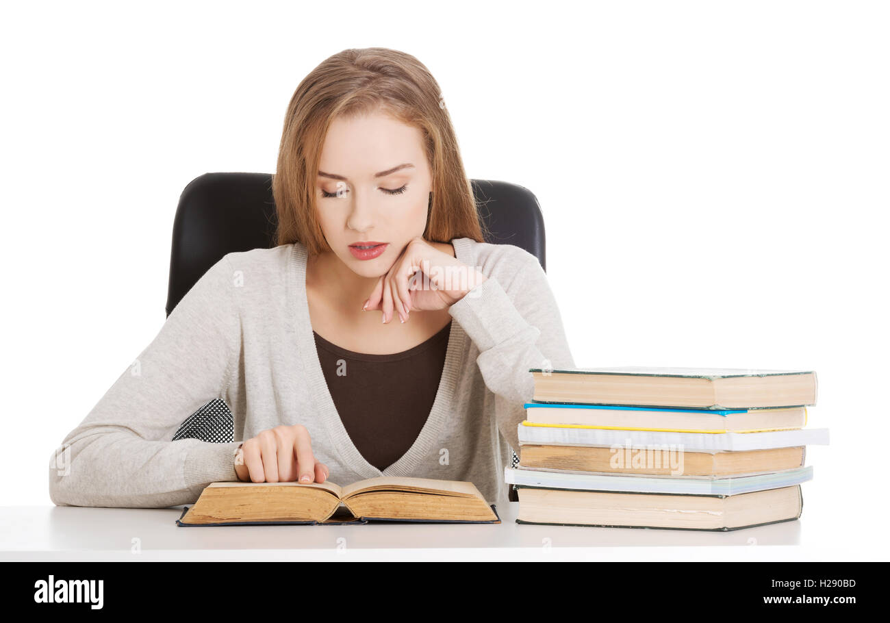 Beautiful casual student woman sitting by stack of books and lea Stock ...