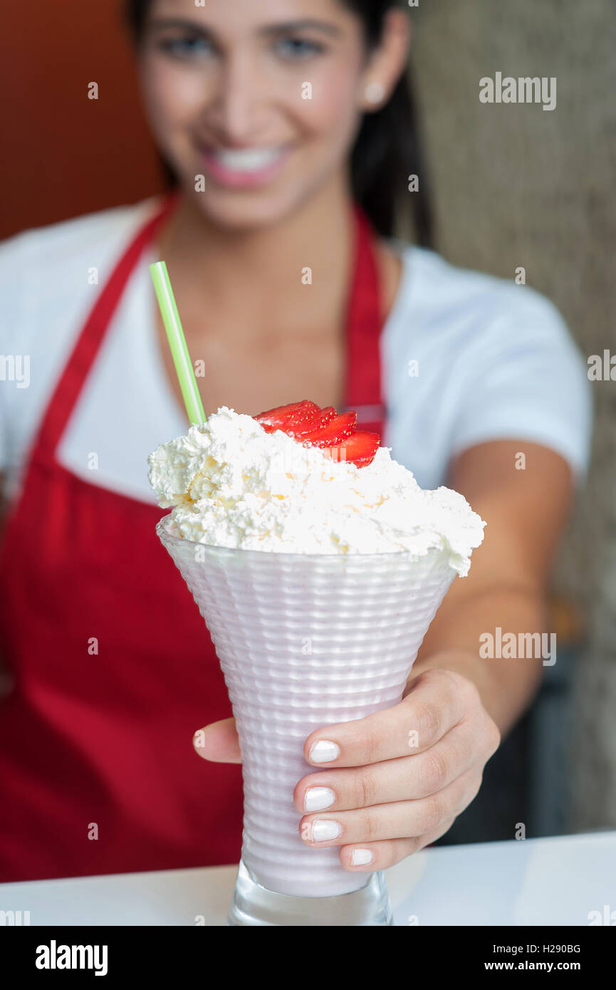 Pretty girl serving strawberry shake Stock Photo - Alamy