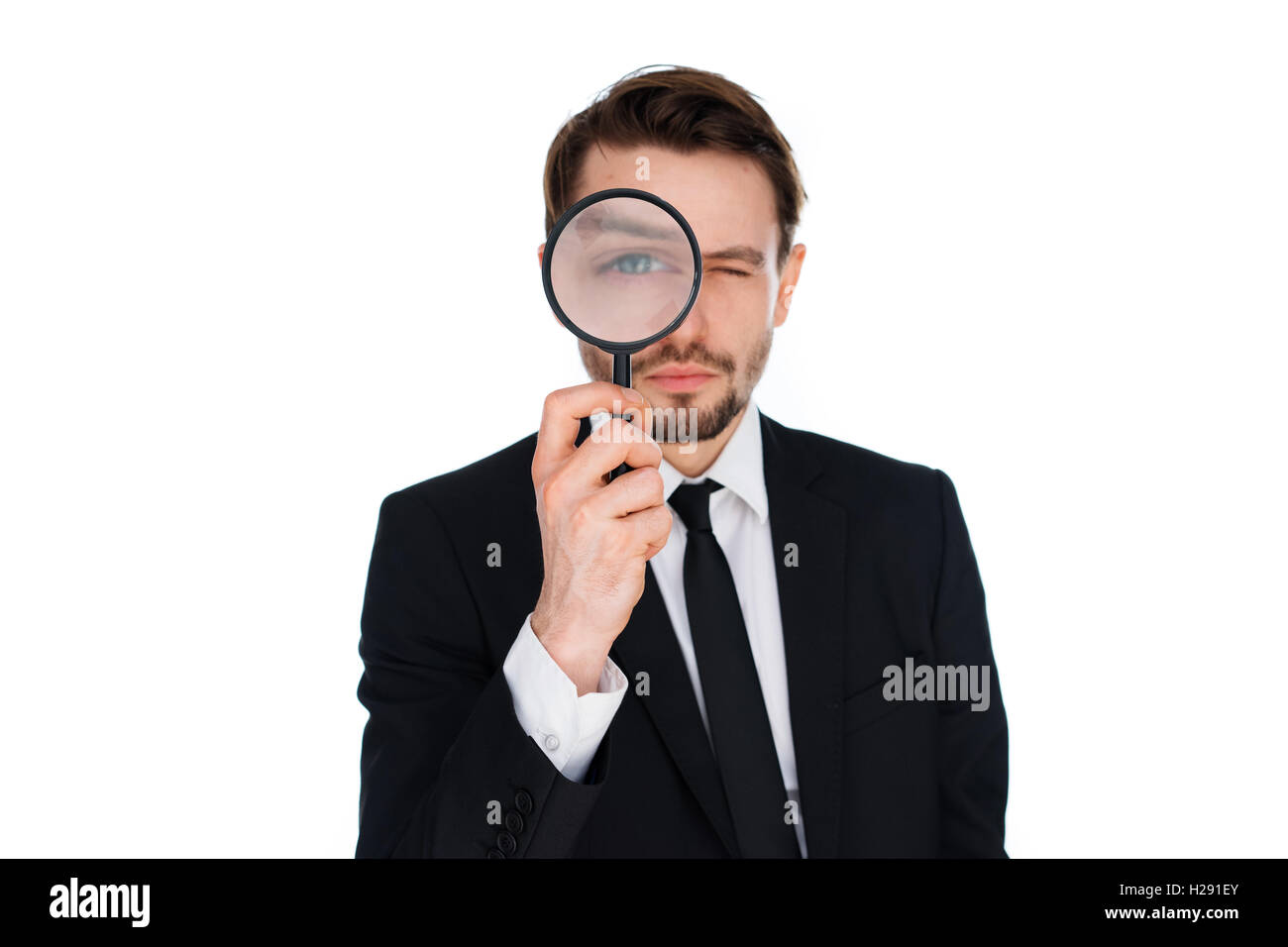 Businessman looking through a magnifying glass Stock Photo - Alamy