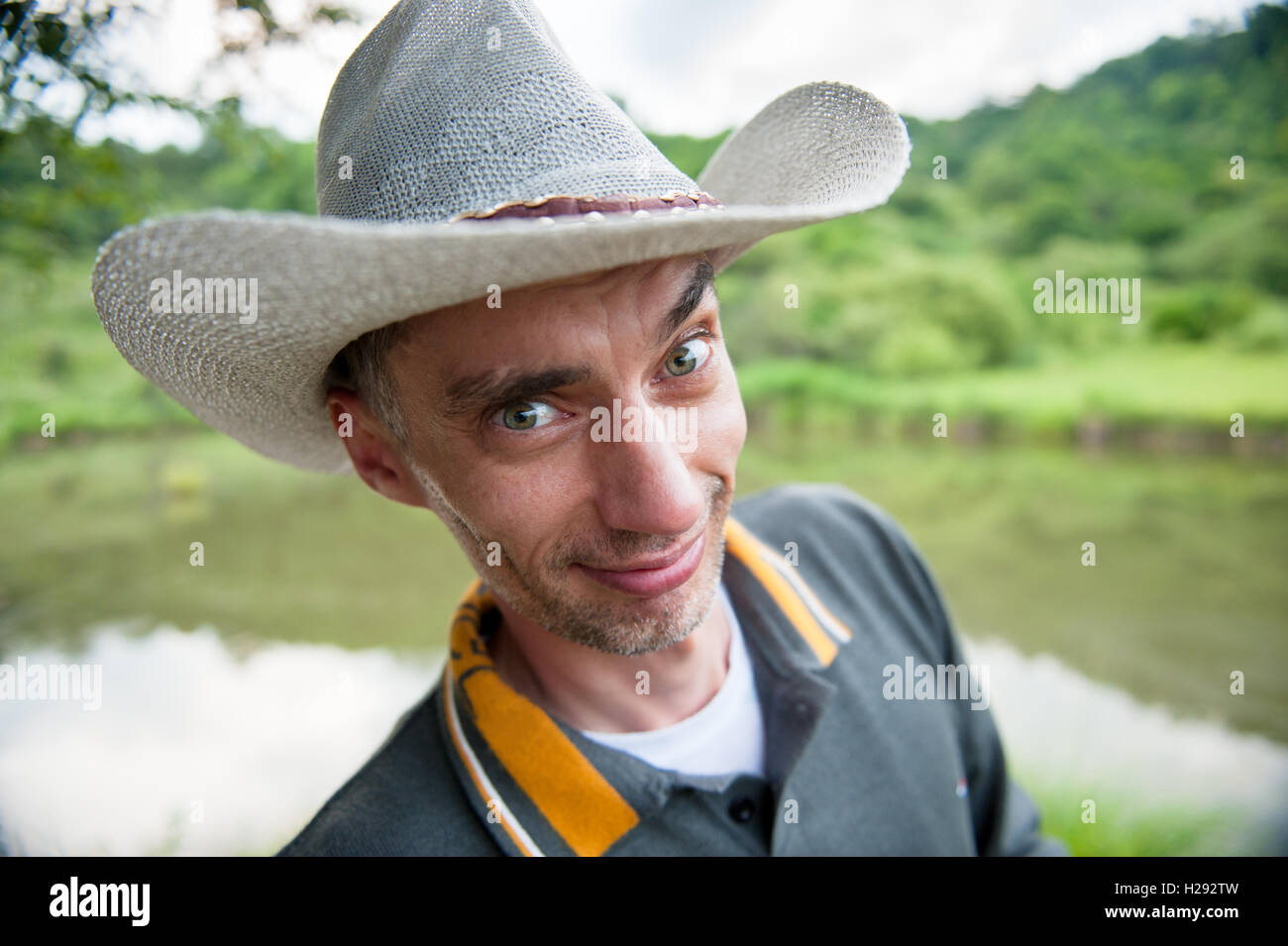 smiling cowboy on the background of greenery and a pond Stock Photo - Alamy