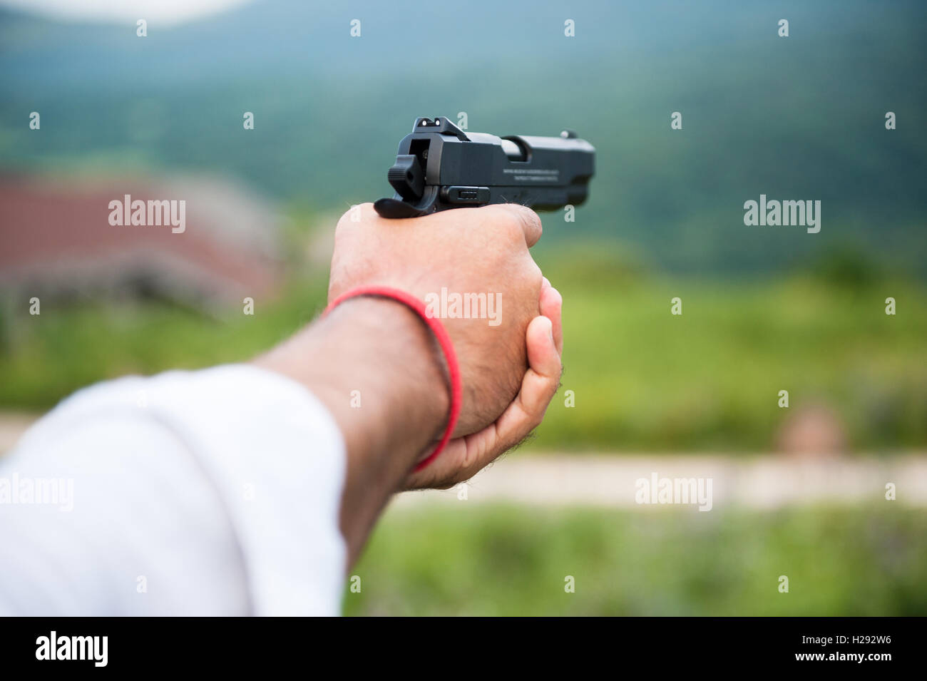 hands of adult man aiming black gun Stock Photo - Alamy