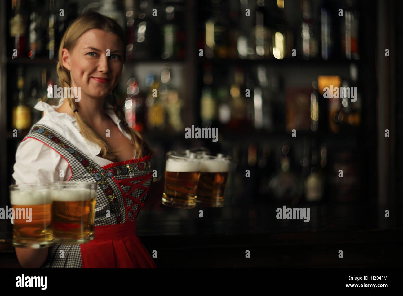 Pretty oktoberfest blonde woman holding beer mugs in bar Stock Photo ...