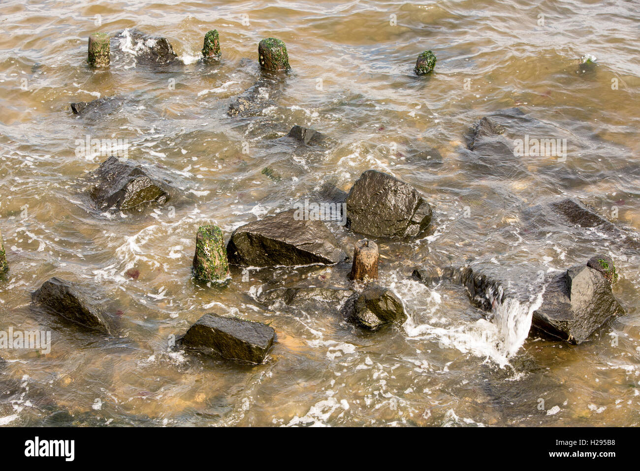 Boulders,pilings and water Stock Photo - Alamy