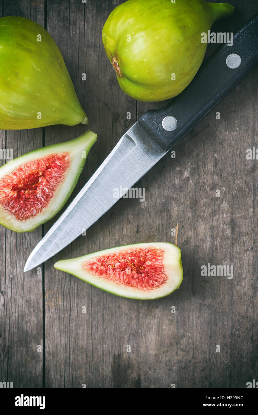 Fresh ripe green figs and knife on rustic grey wooden background. Flat ...