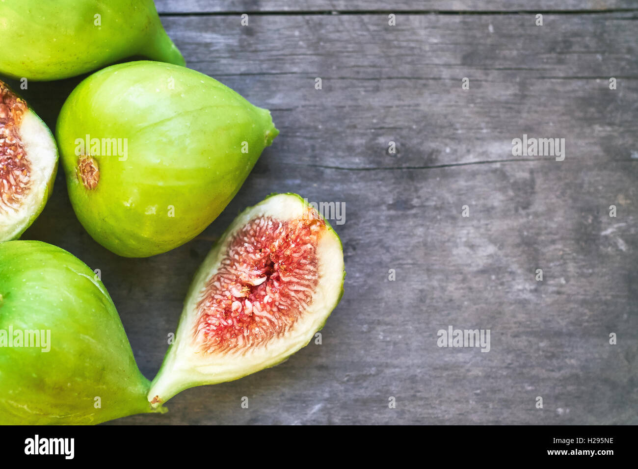Fresh ripe green figs on rustic grey wooden table. Top view with copy ...