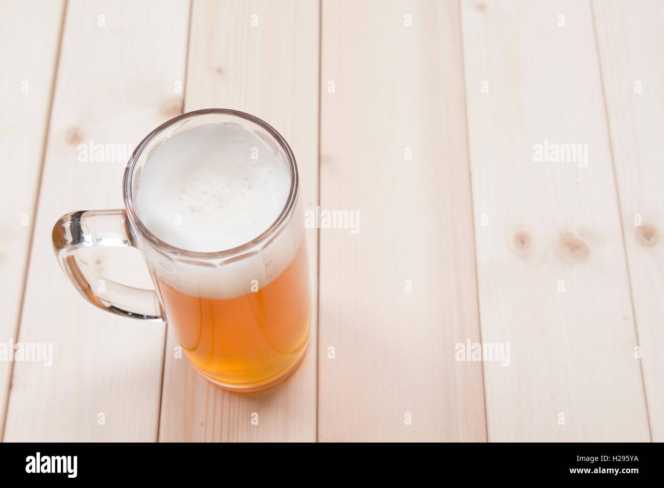 Mug of draft beer on wooden table Stock Photo - Alamy