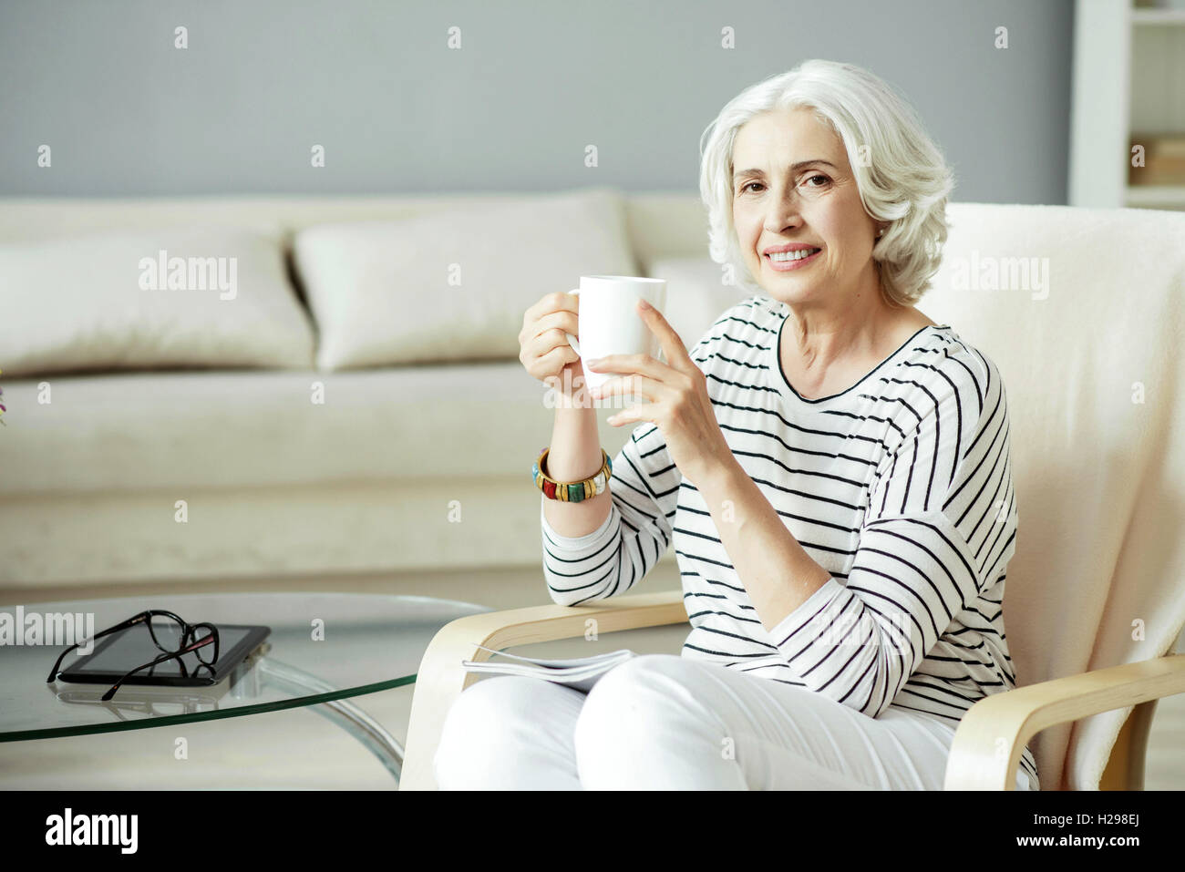 Positive smiling woman drinking tea Stock Photo - Alamy