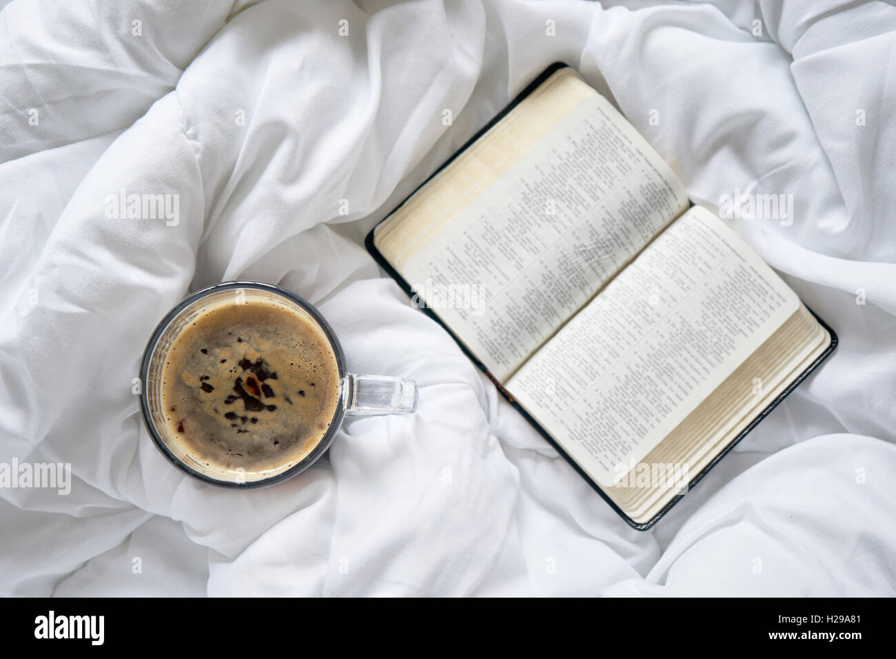Cup of coffee and a book on bed, top view Stock Photo - Alamy