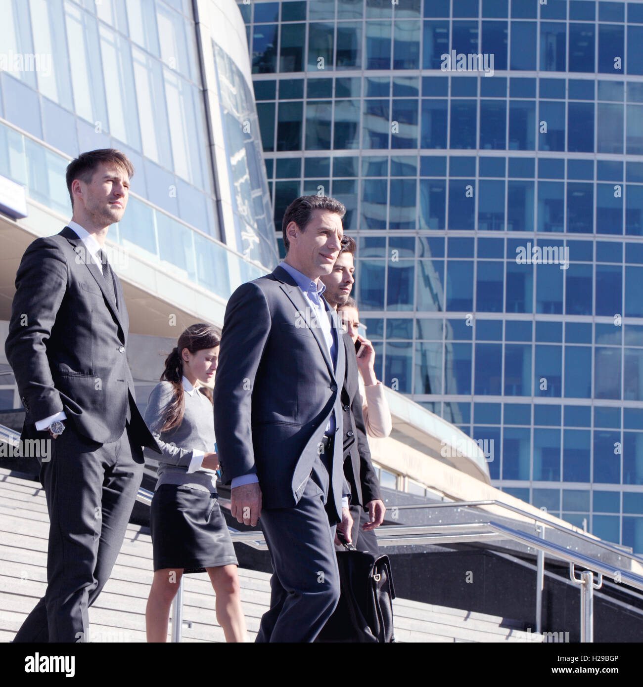 Team of diverse business people at stairs of company office building ...