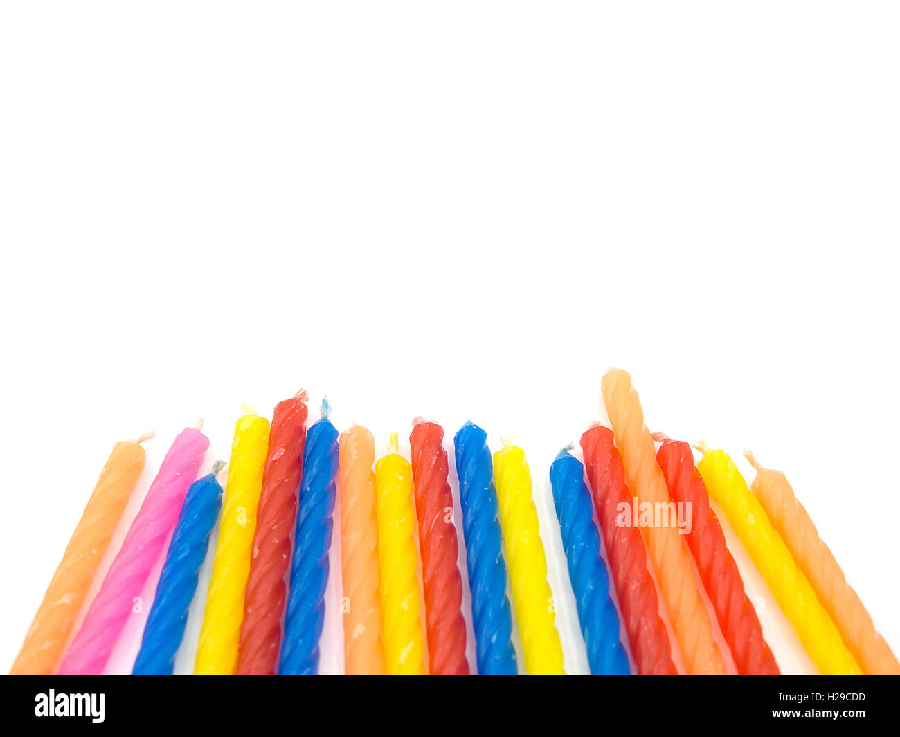 multiple color birthday candles on the white background located on the ...