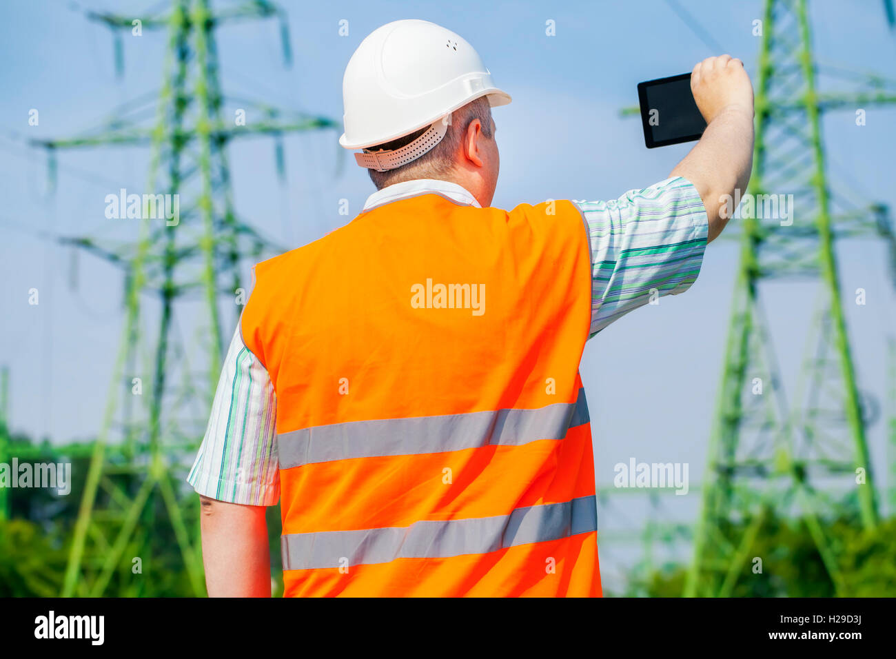 Electrical engineer near high voltage power line Stock Photo - Alamy