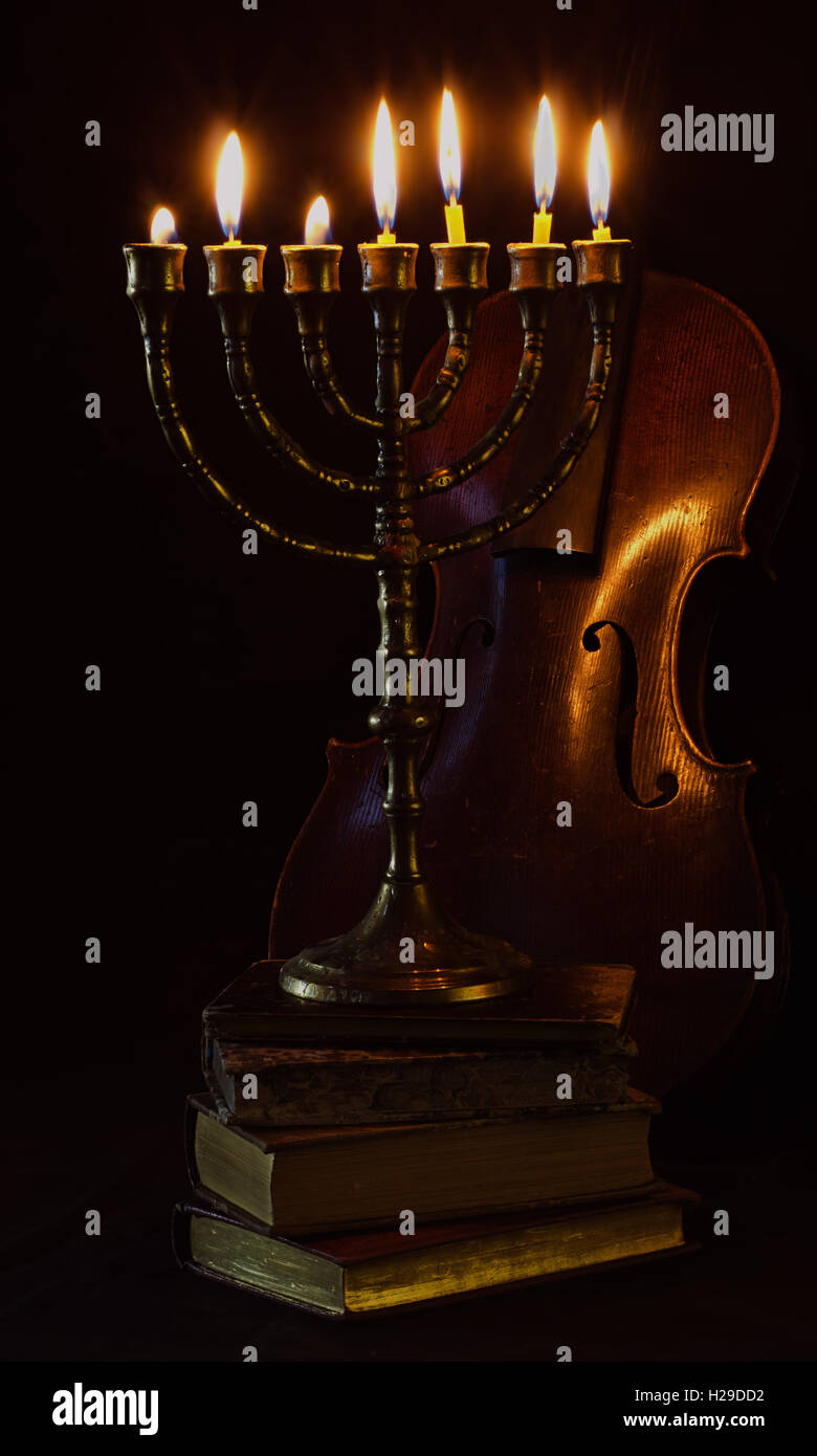 Old menorah over old books. Old violin on the background Stock Photo ...