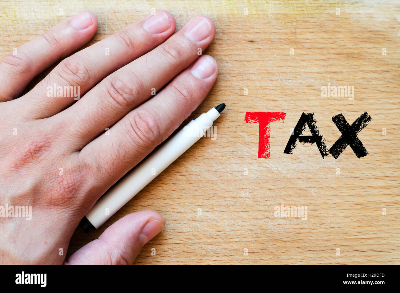 Human hand over wooden background and tax text concept Stock Photo - Alamy