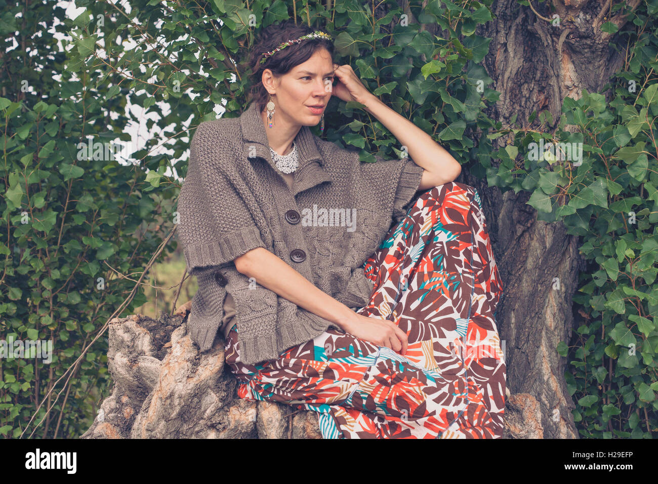 Beautiful woman sitting on the tree and enjoying stillness Stock Photo ...