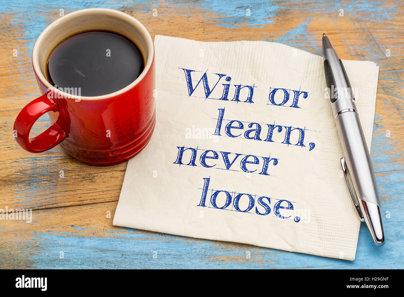 Win or learn, never loose - handwriting on a napkin with a cup of ...
