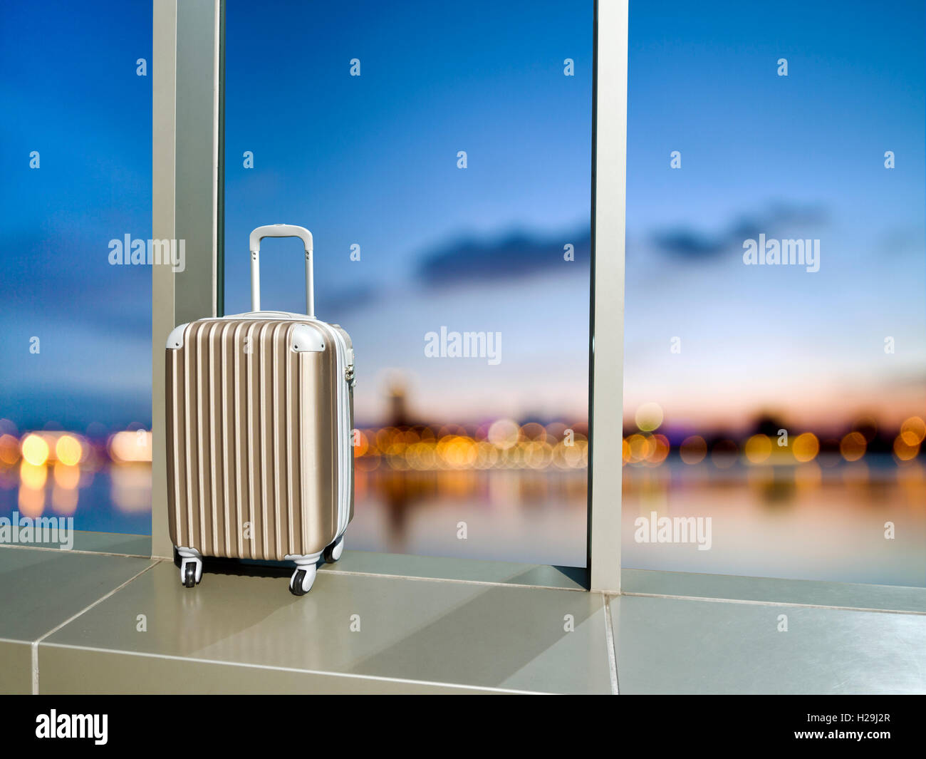 business travel,suitcase at window in tower building against blur ...