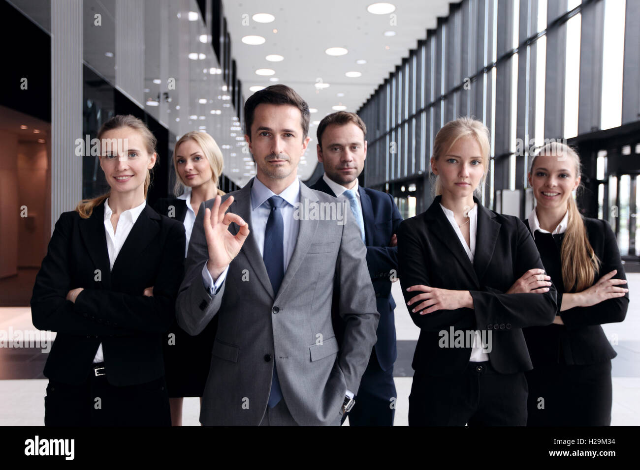 Portrait of successful business man showing ok sign with his team Stock ...