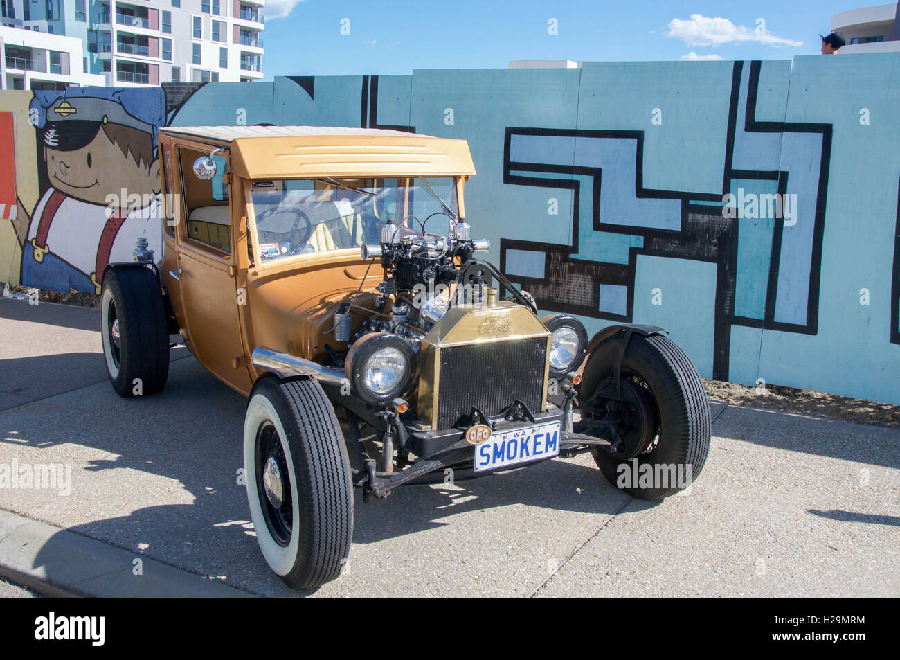 Antique gold car on display at the Billy Car Races in front of boundary ...