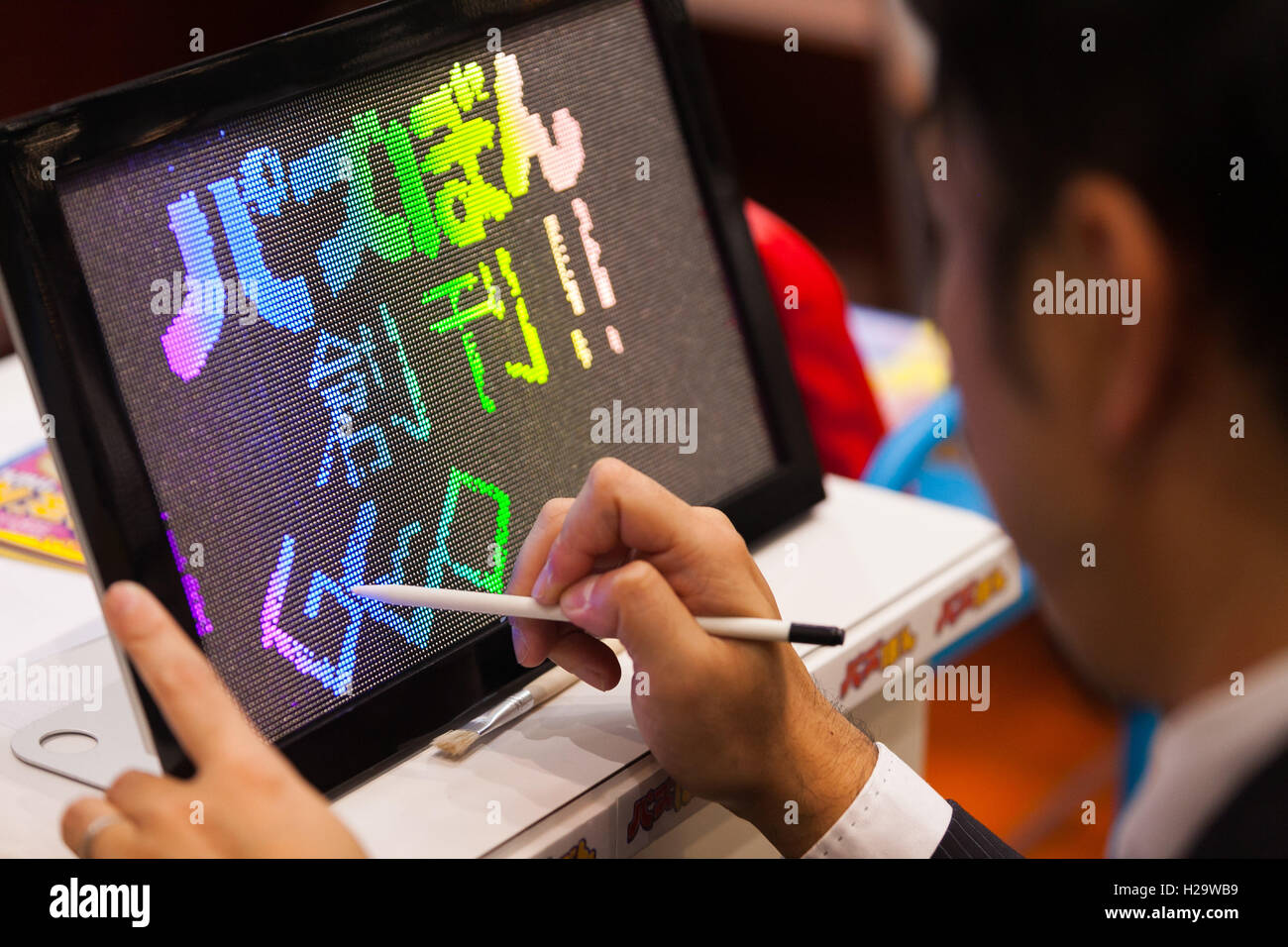 A visitor draws on a shining screen Rainbow Panel, made by 14,000 ...