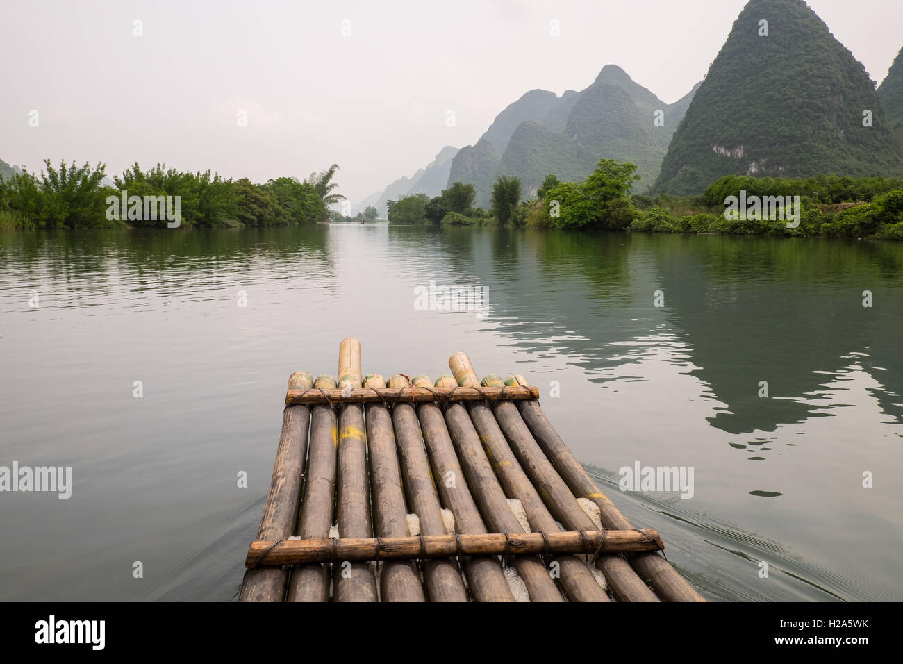 Sailing in bamboo raft on Yulong River surrounded by karst mountains in ...