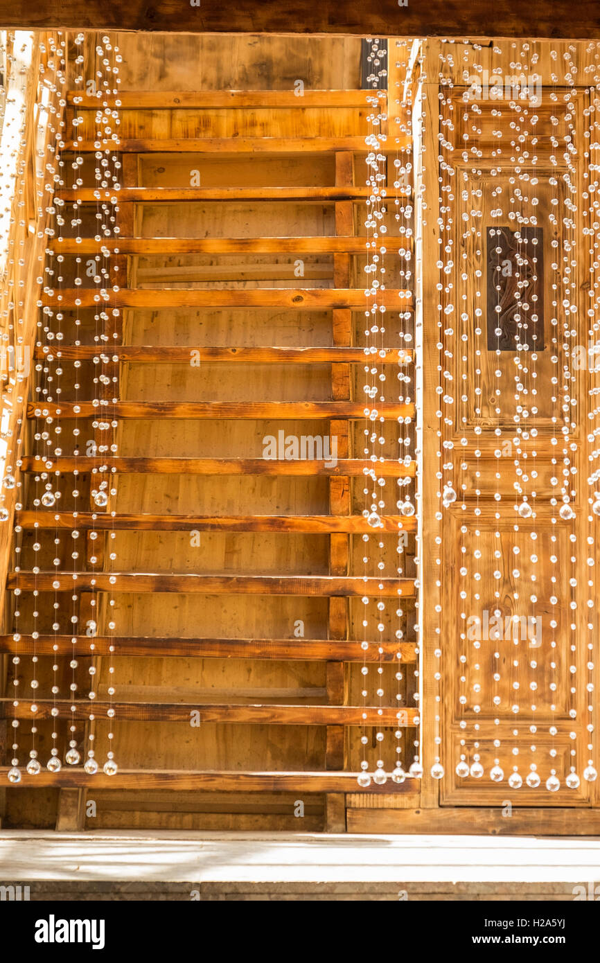 Backdrop of beaded blinds in front of wooden stairs and door Stock ...