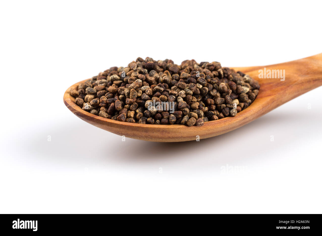 Decorticated cardamom seeds in a wooden spoon on white background Stock ...