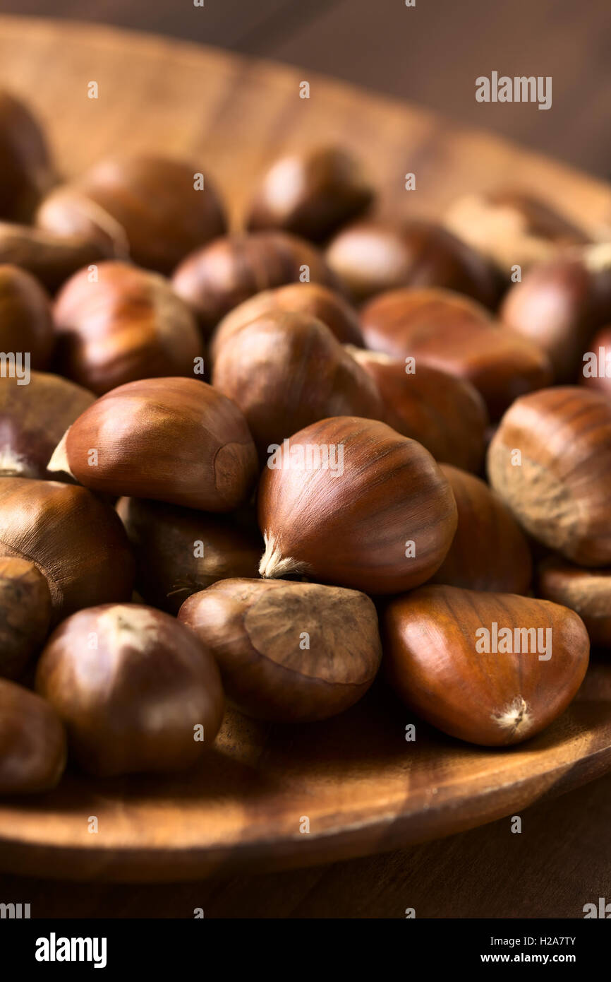 Chestnuts on wooden plate, photographed with natural light (Selective ...