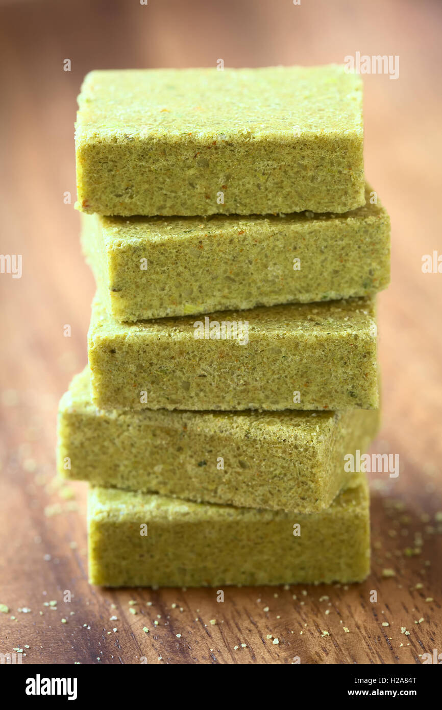 Vegetable bouillon, stock or broth cubes on wooden plate, photographed ...