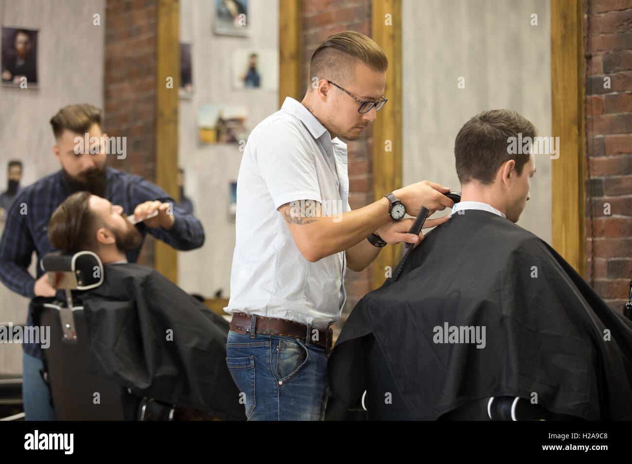 Interior shot of working process in barbershop. Back view of handsome ...