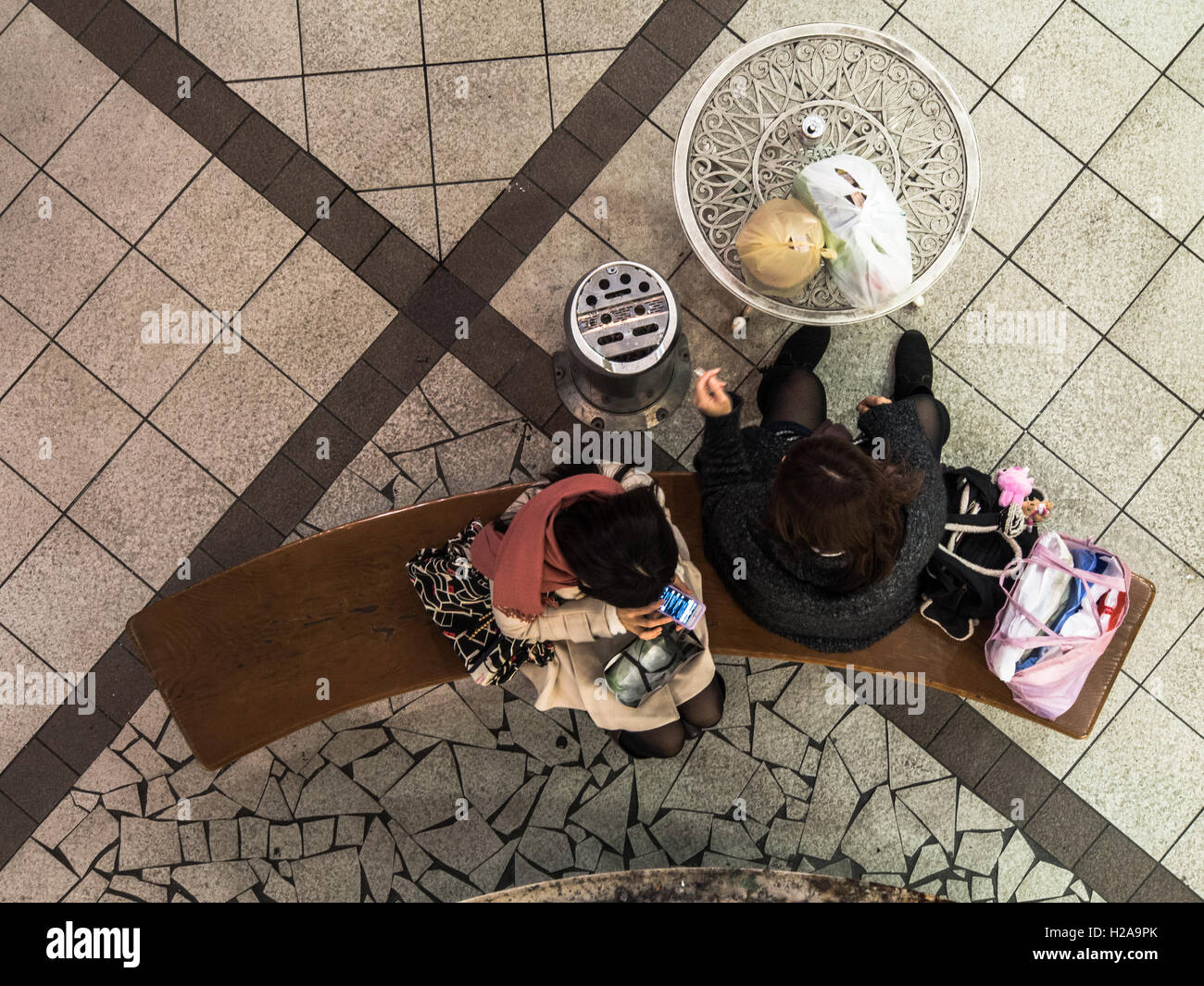 Man and woman sitting on bench seen from above, abstract design a ...