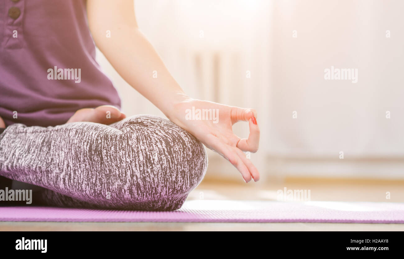 Girl doing yoga indoors in lotus asana Stock Photo - Alamy