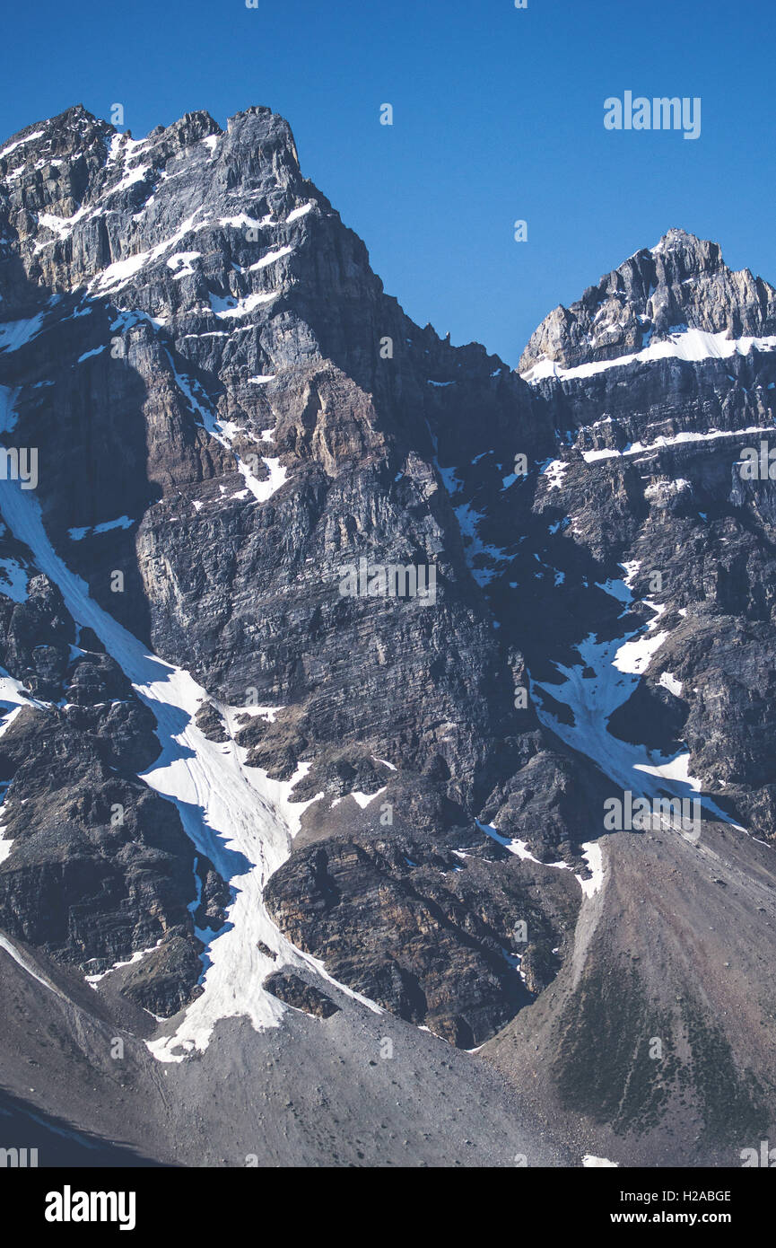 Rough mountain with cliffs and snow in blue sky Stock Photo - Alamy