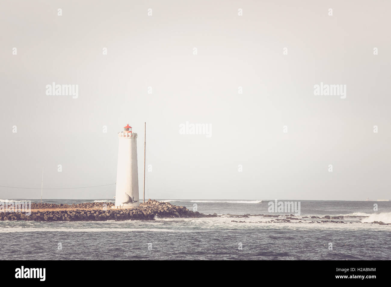 Lighthouse on a small island in the ocean Stock Photo - Alamy