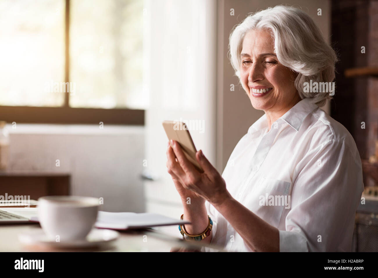 Happy middle-aged lady getting a message Stock Photo - Alamy