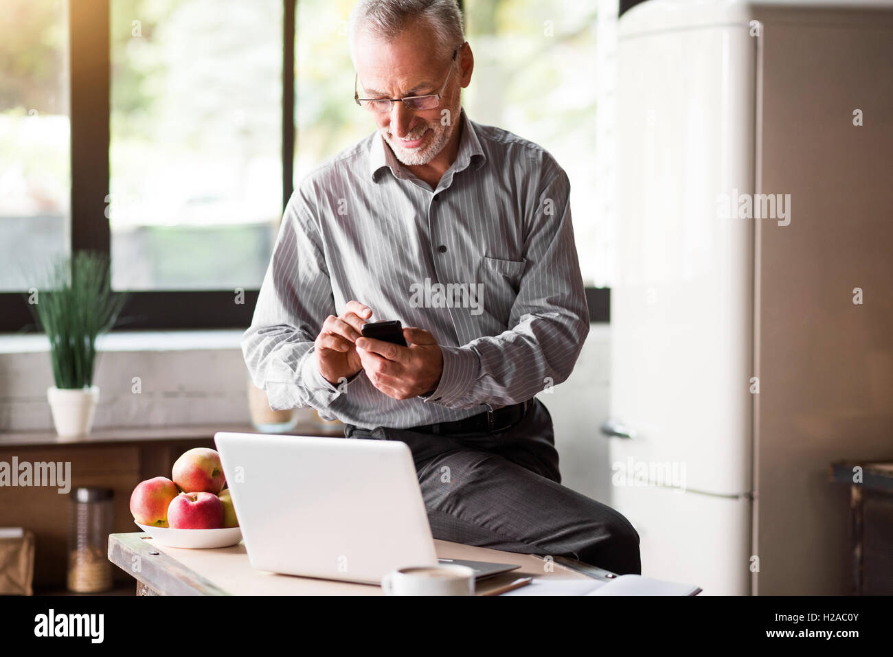 Smiling businessman getting a message on his smartphone Stock Photo - Alamy