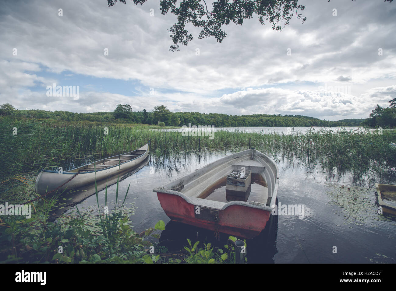 Idyllic lake with a small boat and a canoe Stock Photo - Alamy