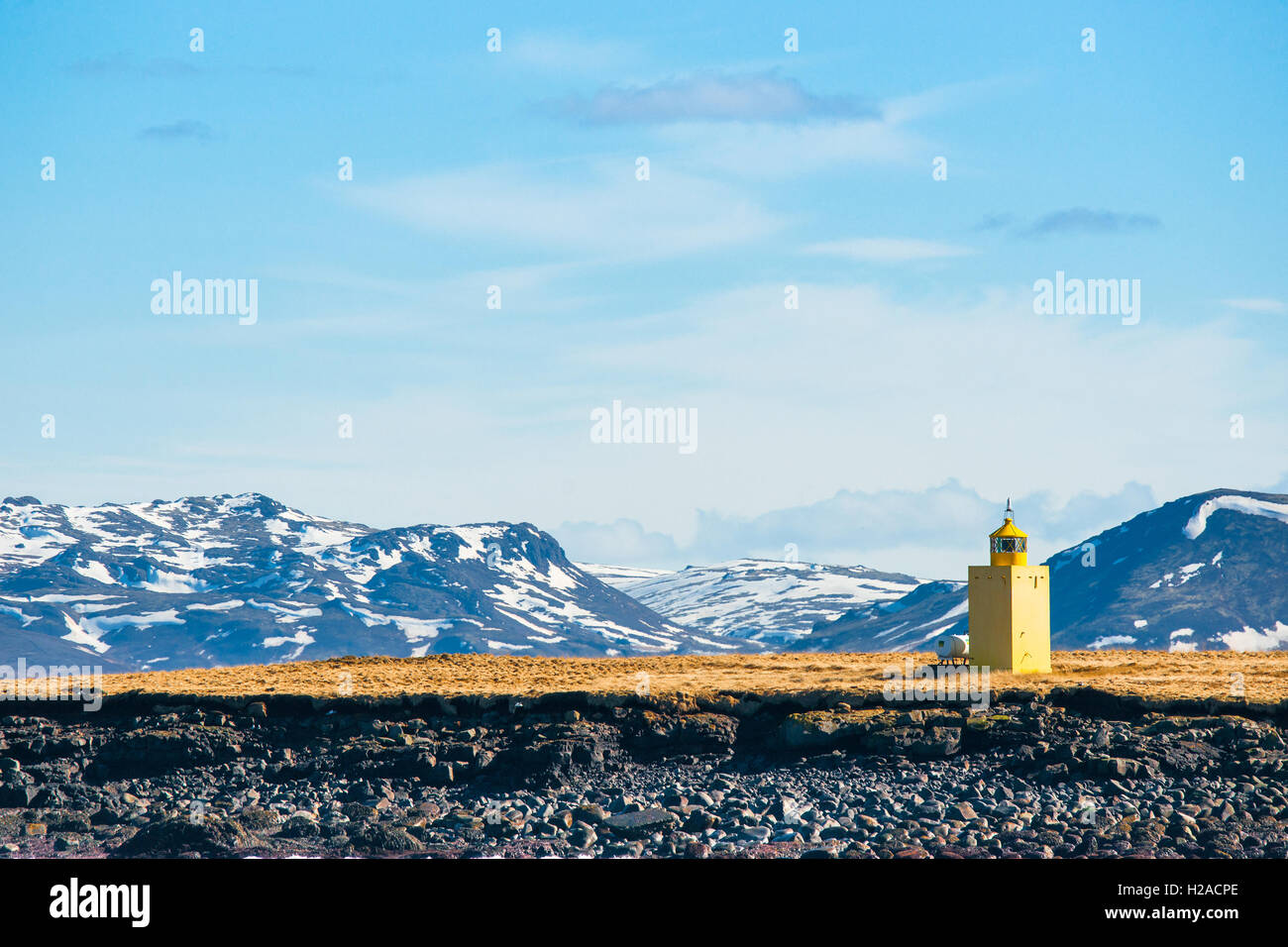 Lighthouse in yellow color in a landscape with mountains Stock Photo ...