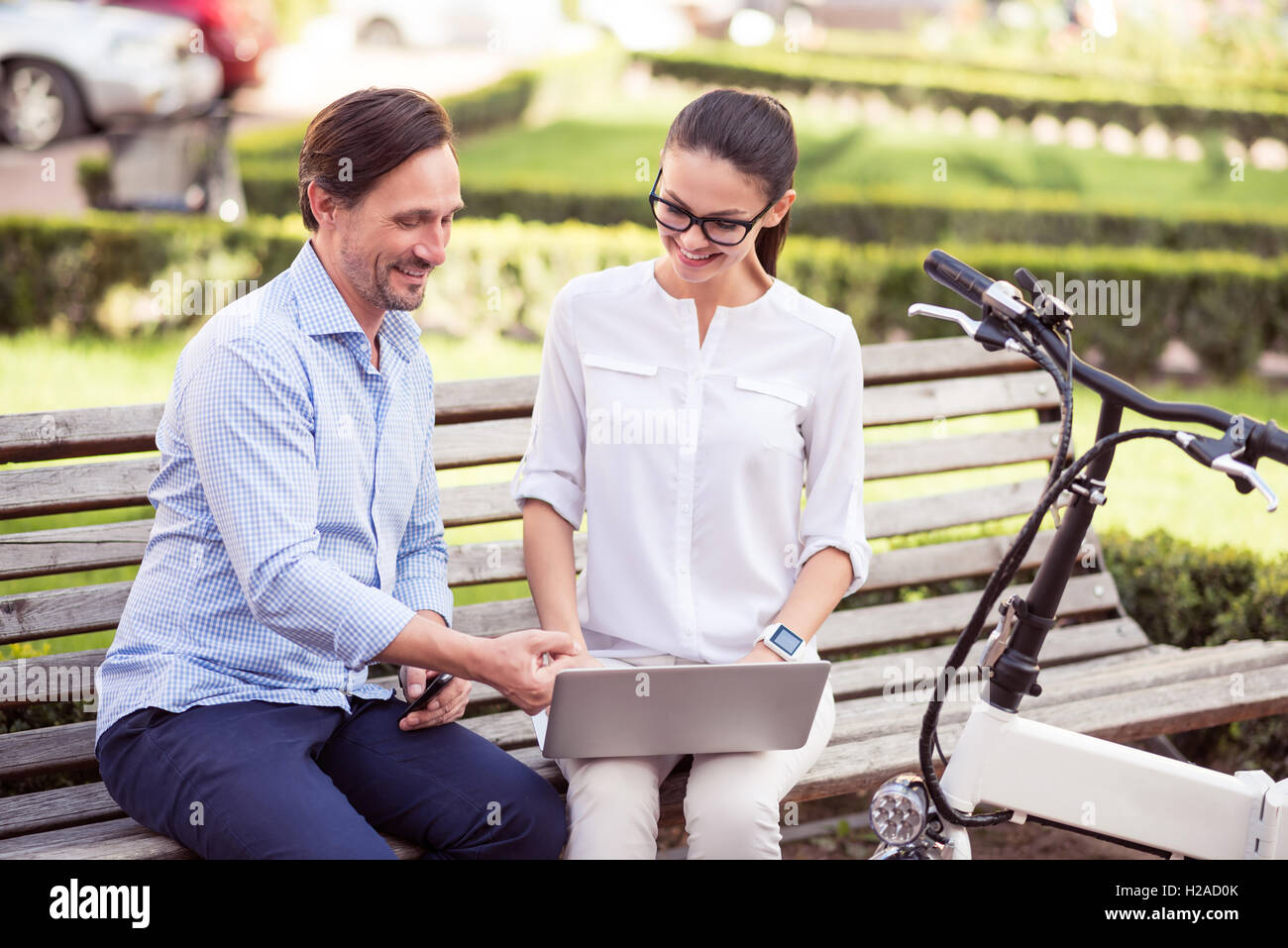 Cheerful friends sitting on the bench Stock Photo - Alamy