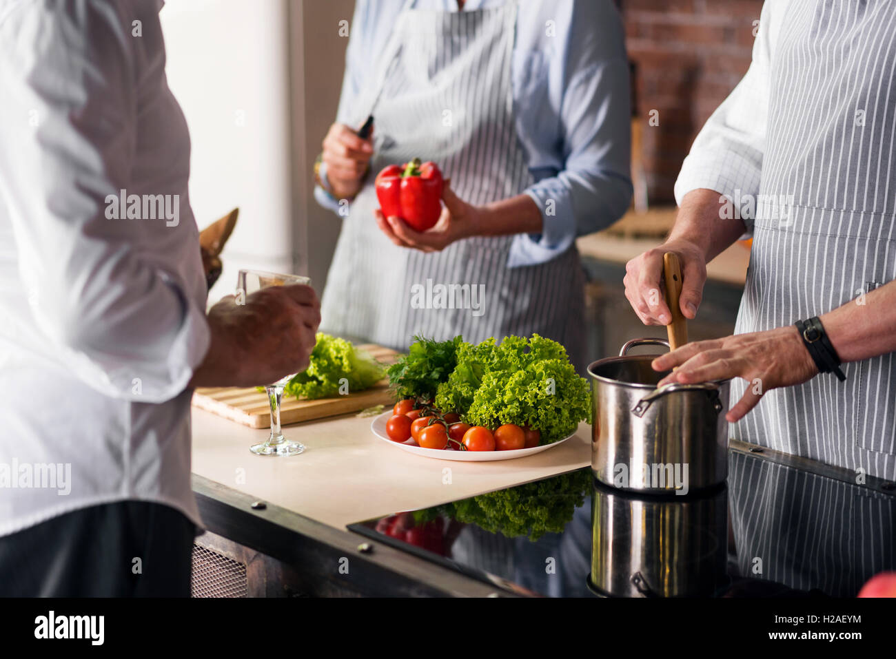 People gathered around kitchen table for cooking and chatting Stock ...