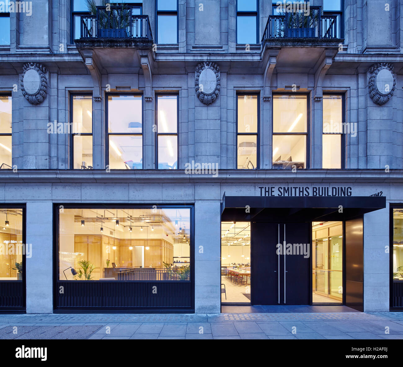 The facade of the building glowing at night with entrance and signage ...