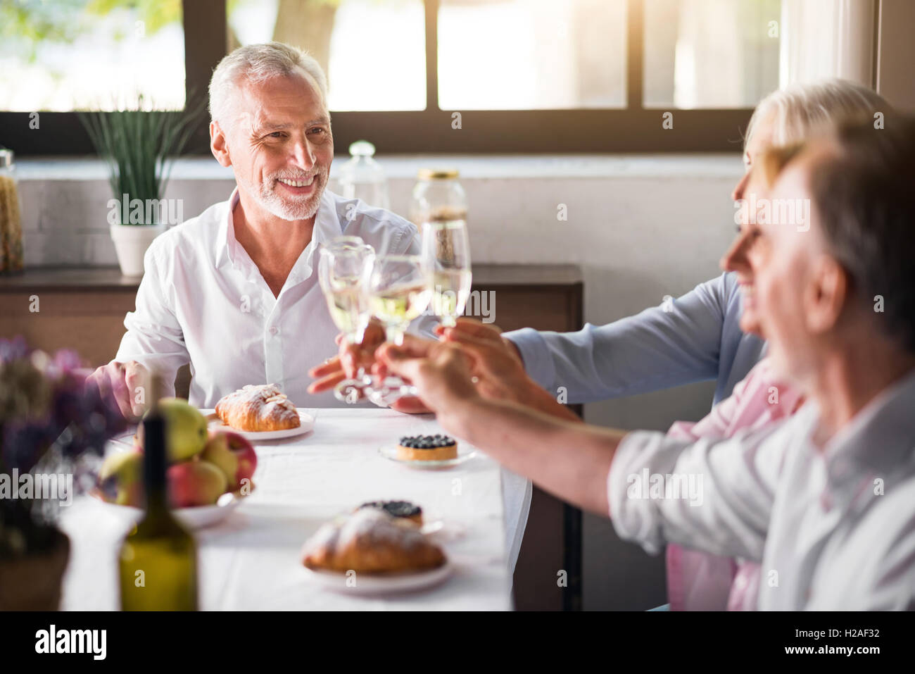 Group of friends toasting with champagne in the kitchen Stock Photo - Alamy
